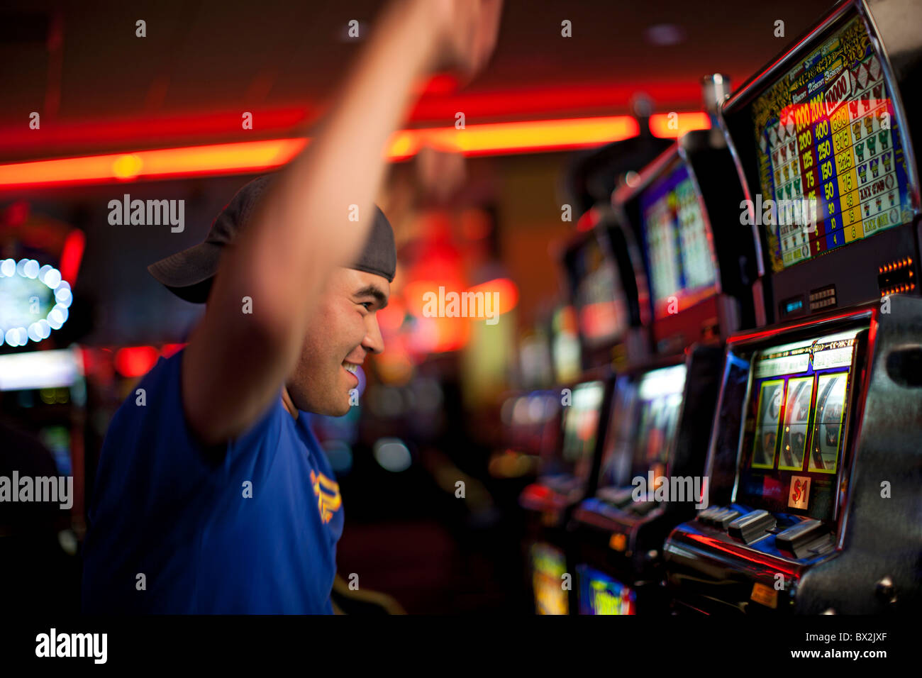 Cheering Native American man playing slot machines in casino Stock ...