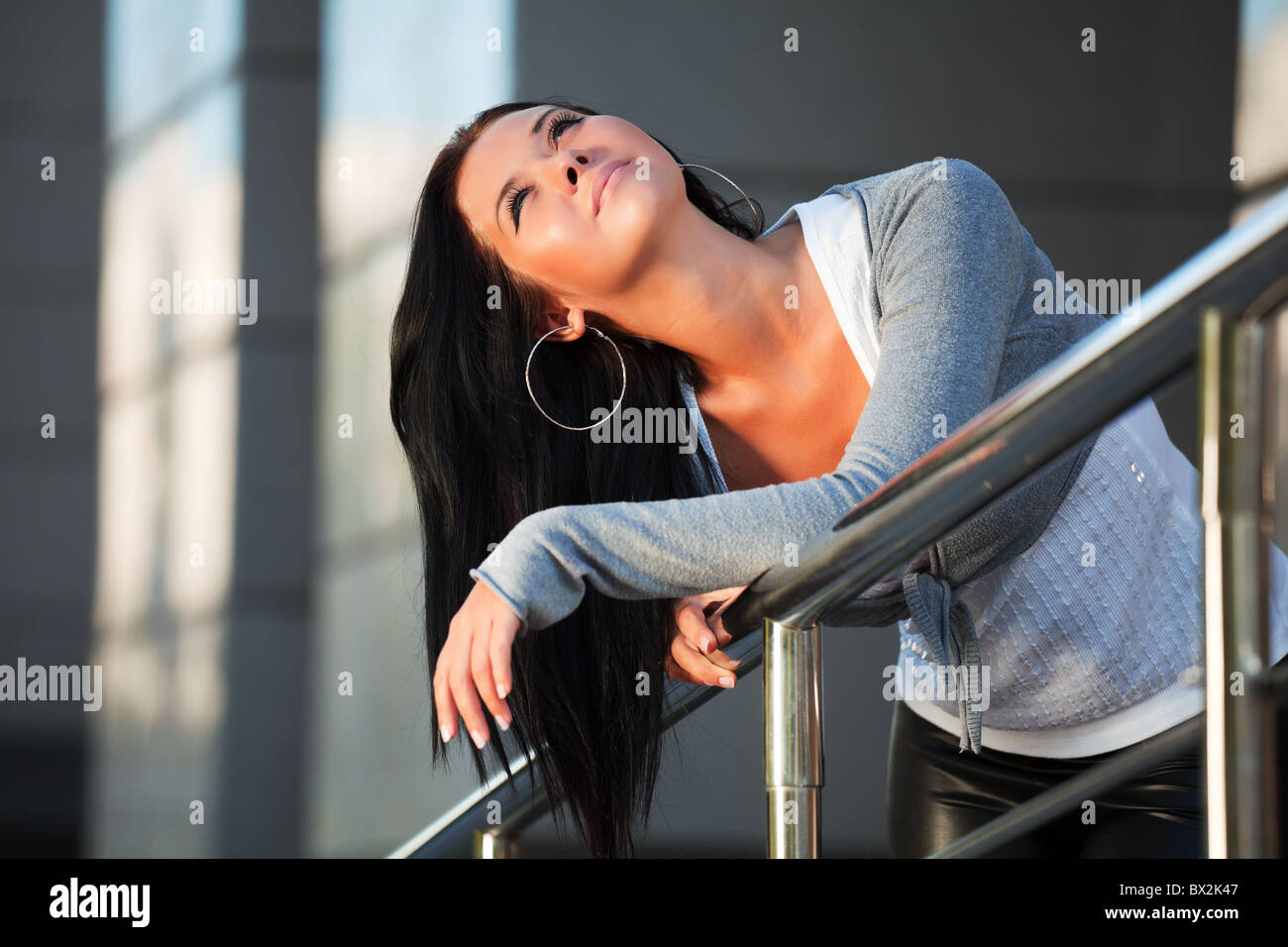 Beautiful young woman leaning on the handrail Stock Photo - Alamy