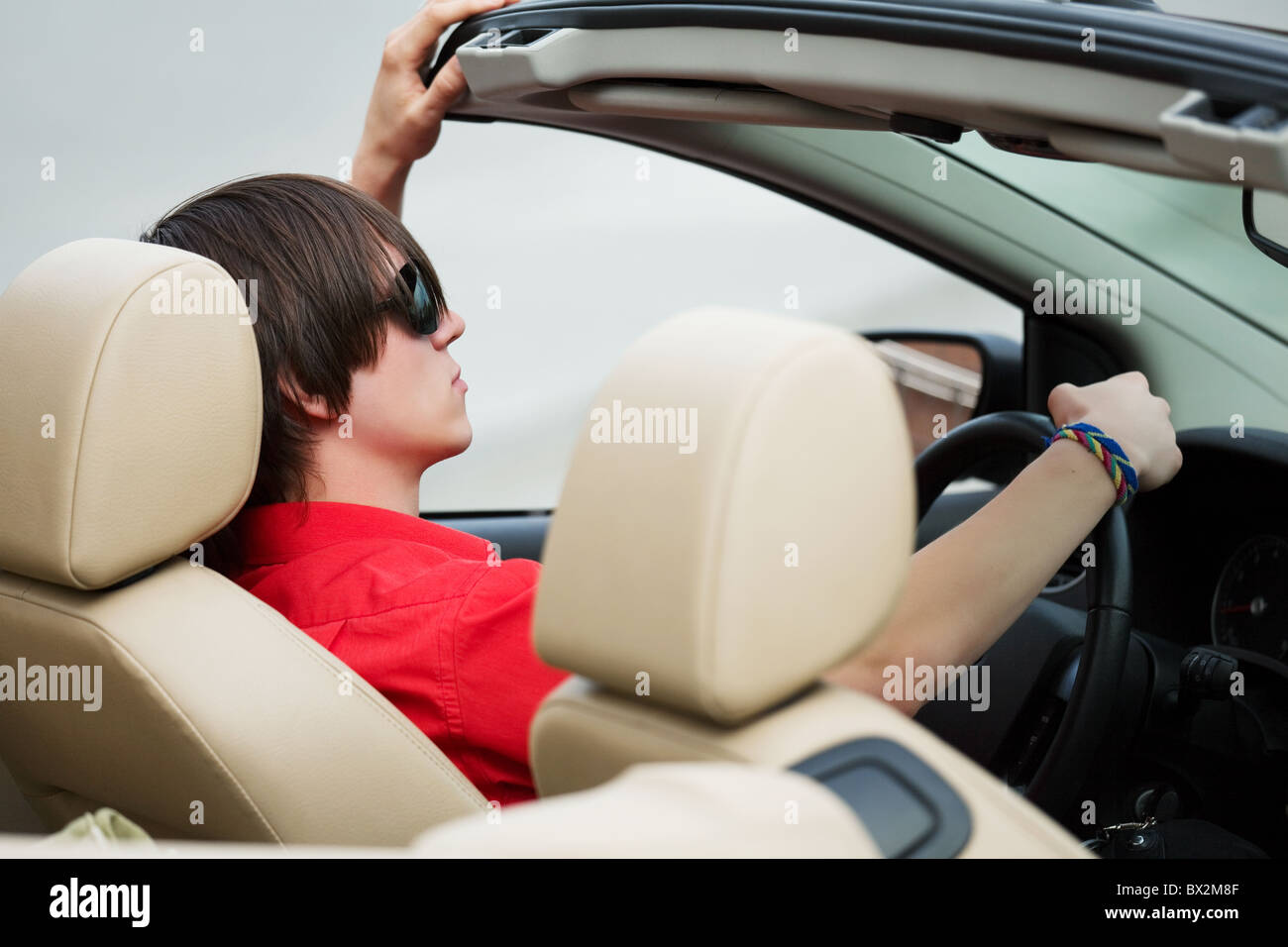 Young man driving a new convertible car Stock Photo - Alamy