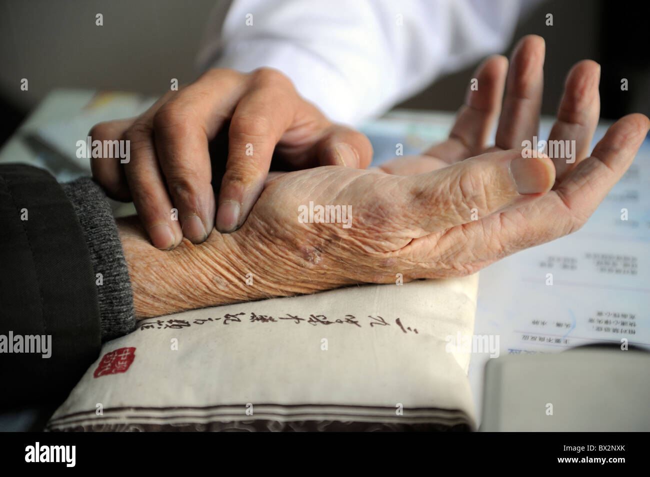 Doctor of traditional Chinese medicine checking an old man's pulse in a ...