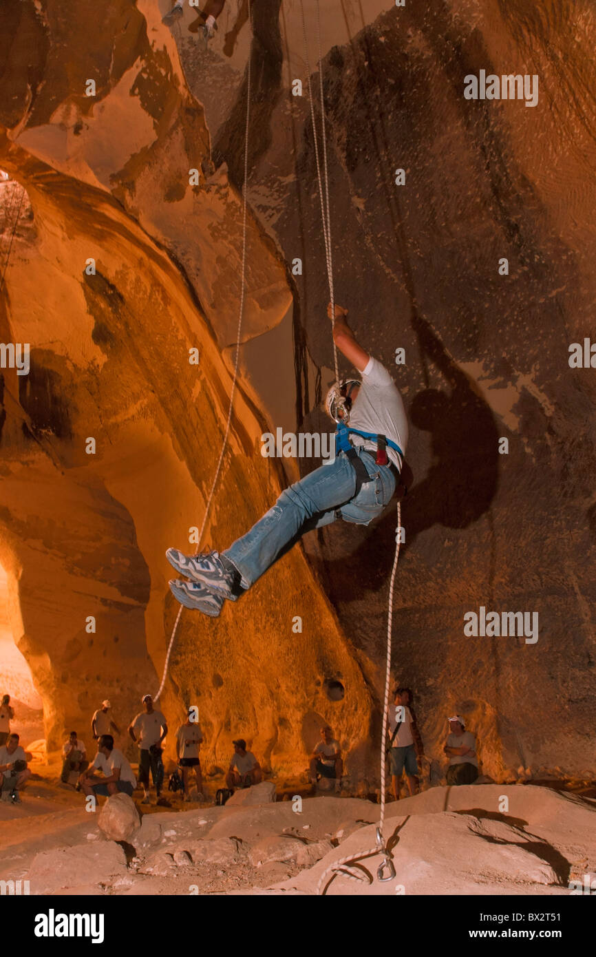 A man descends down a rope rope from the top of the bell caves near ...