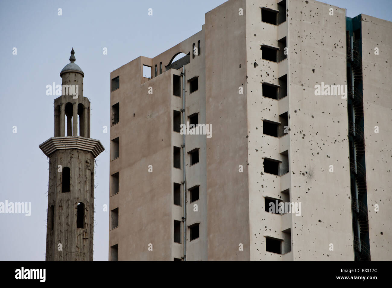 Bullet holes scar a high-rise building next to a newly constructed ...