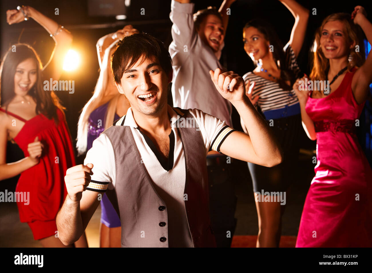 Portrait of energetic dancer on background of happy friends having fun ...