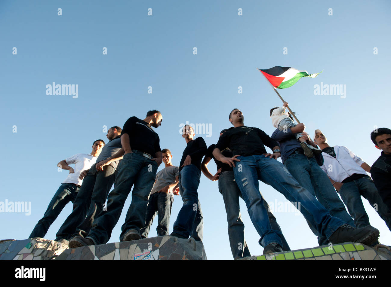 A Palestinian boy makes a peace sign as protesters fly the Palestinian ...