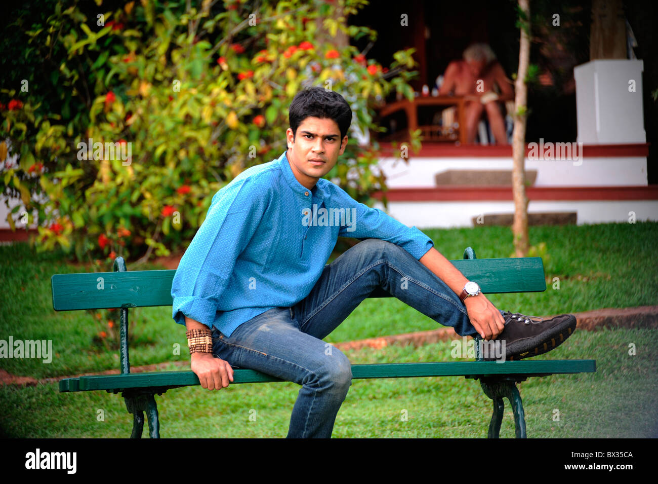 An Indian boy sitting on garden bench Stock Photo - Alamy