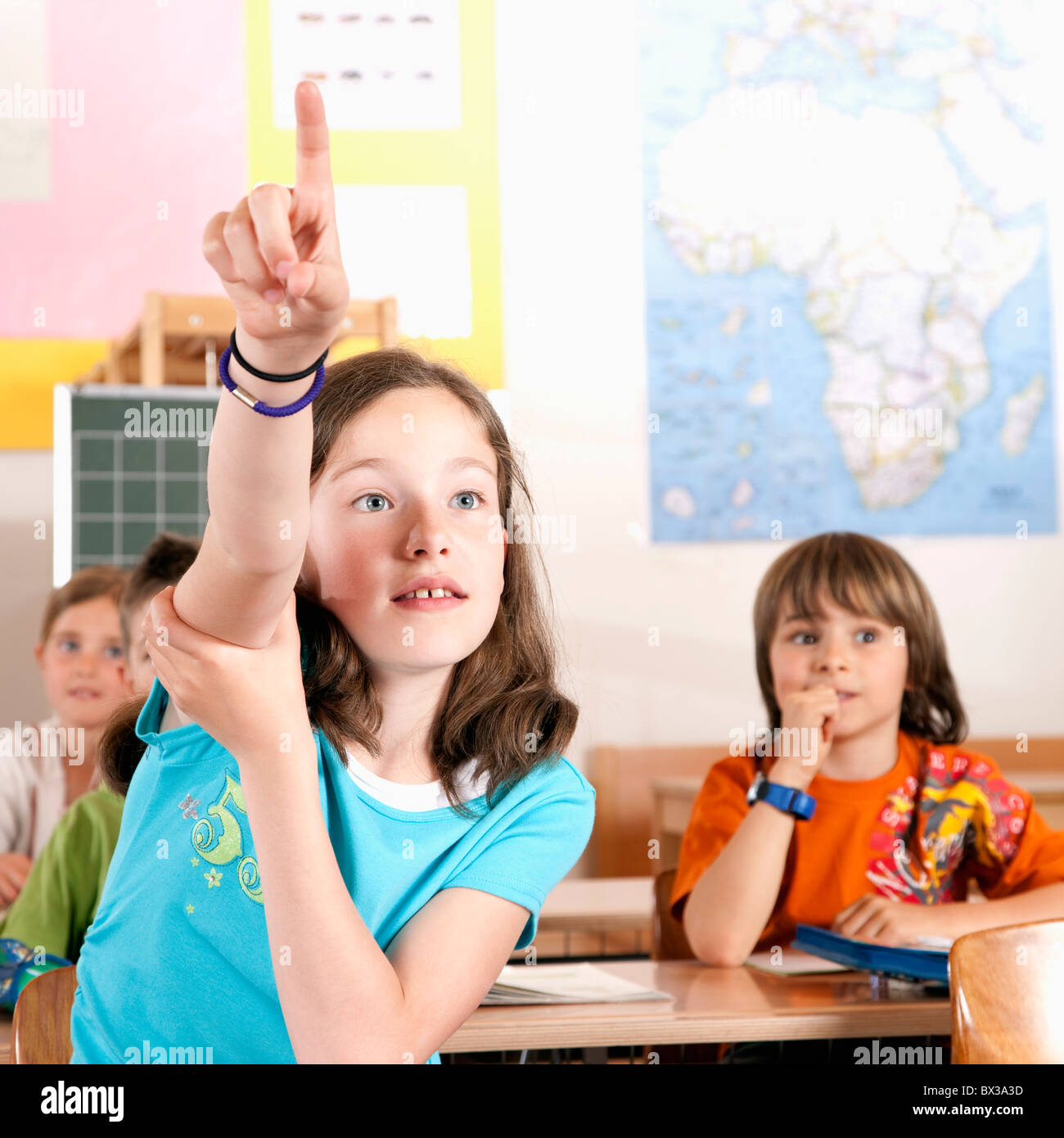 portrait of young girl raising her finger in classroom Stock Photo - Alamy