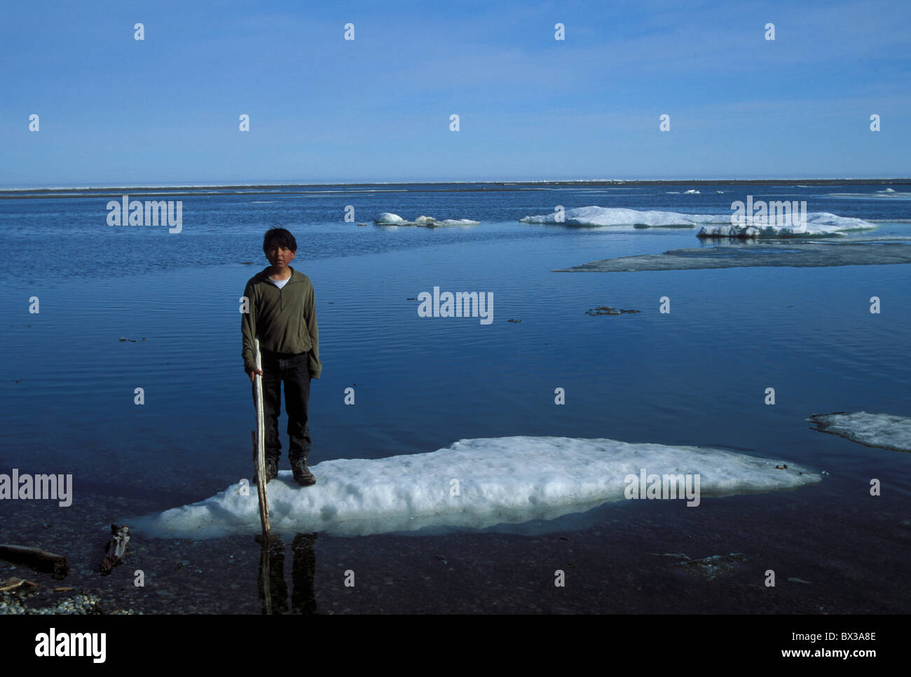 Boy Inuit standing iceblock shore Beaufort Sea Barter Island Arctic ...