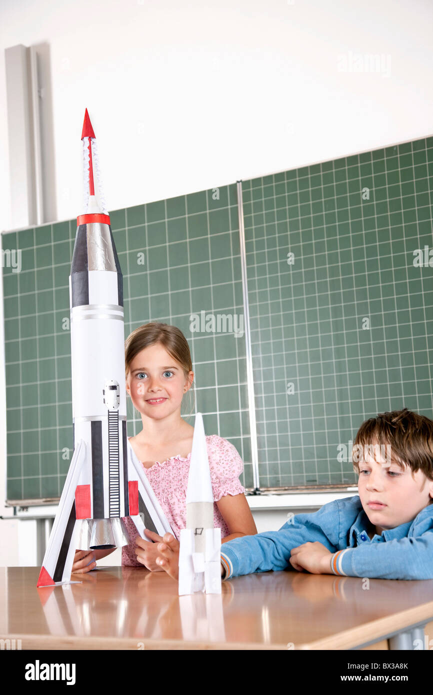 two pupils in classroom with model of rocket Stock Photo - Alamy