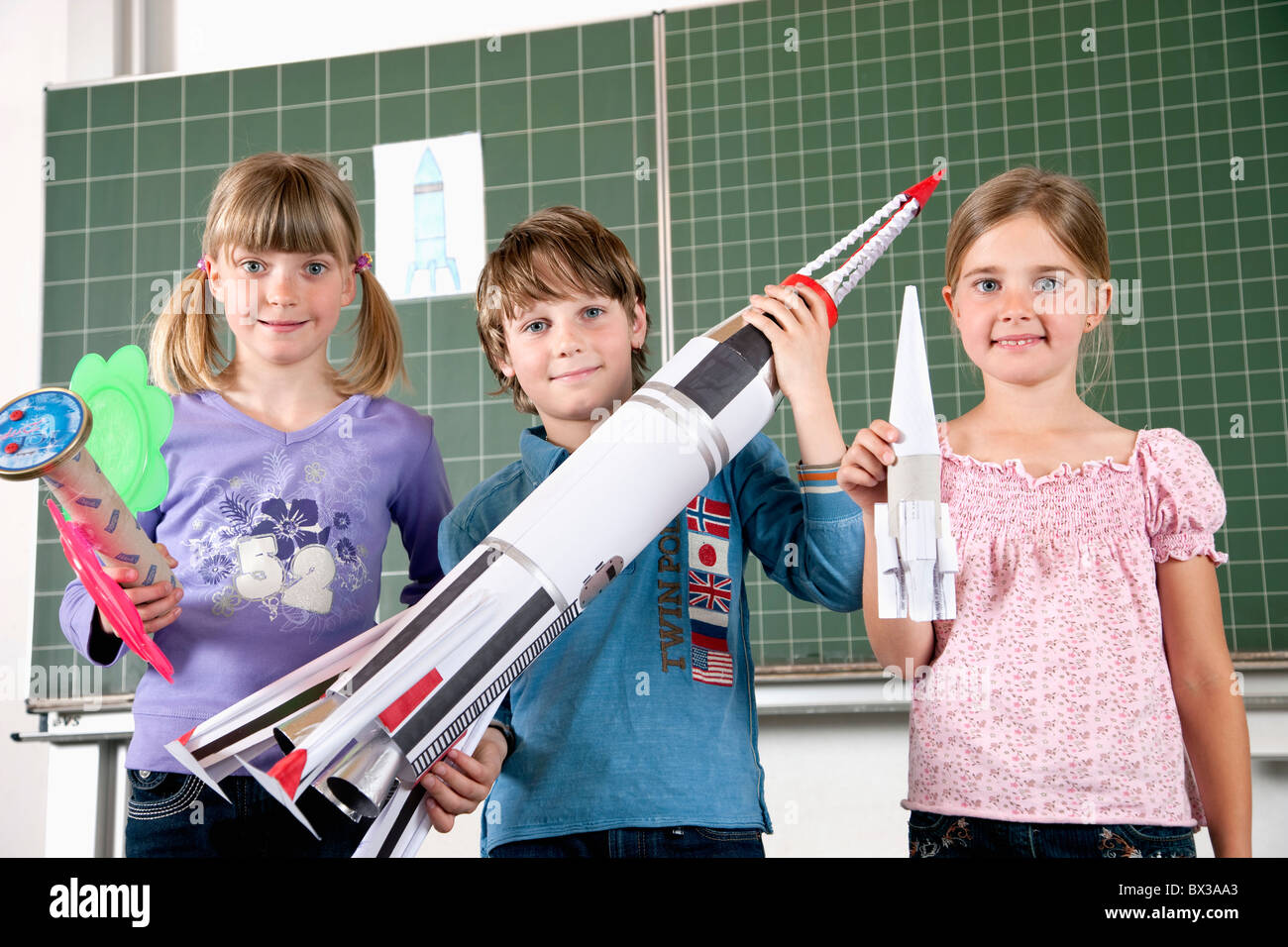young pupils in classroom holding models of rockets Stock Photo - Alamy