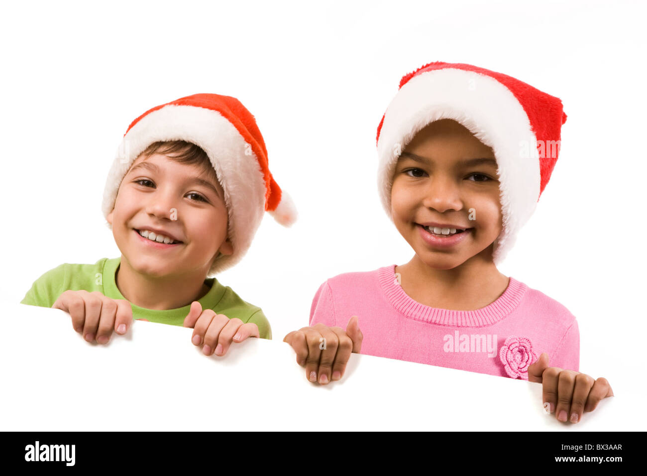 Photo of happy friends in Santa caps smiling at camera Stock Photo - Alamy
