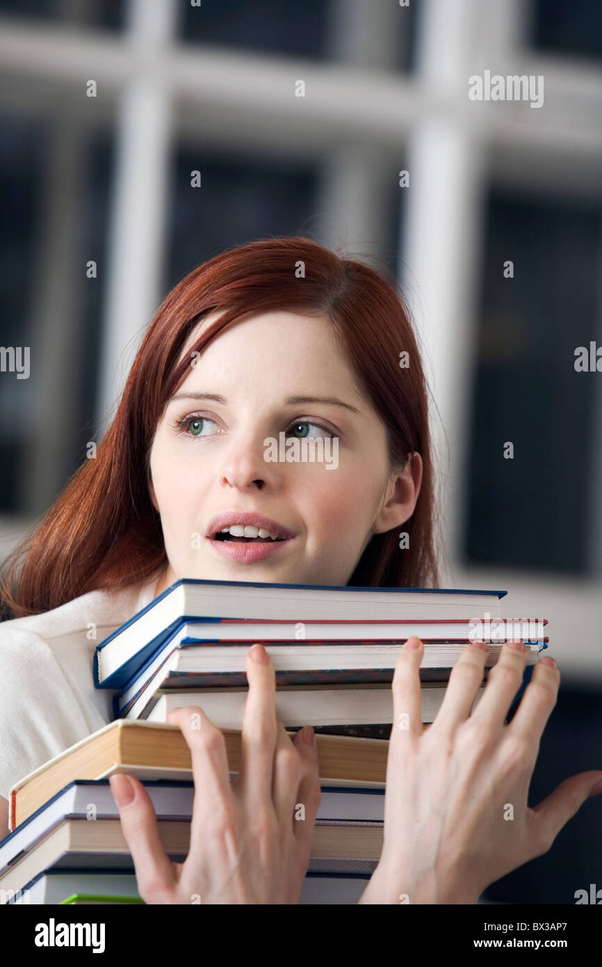 portrait of female student carrying pile of books Stock Photo - Alamy
