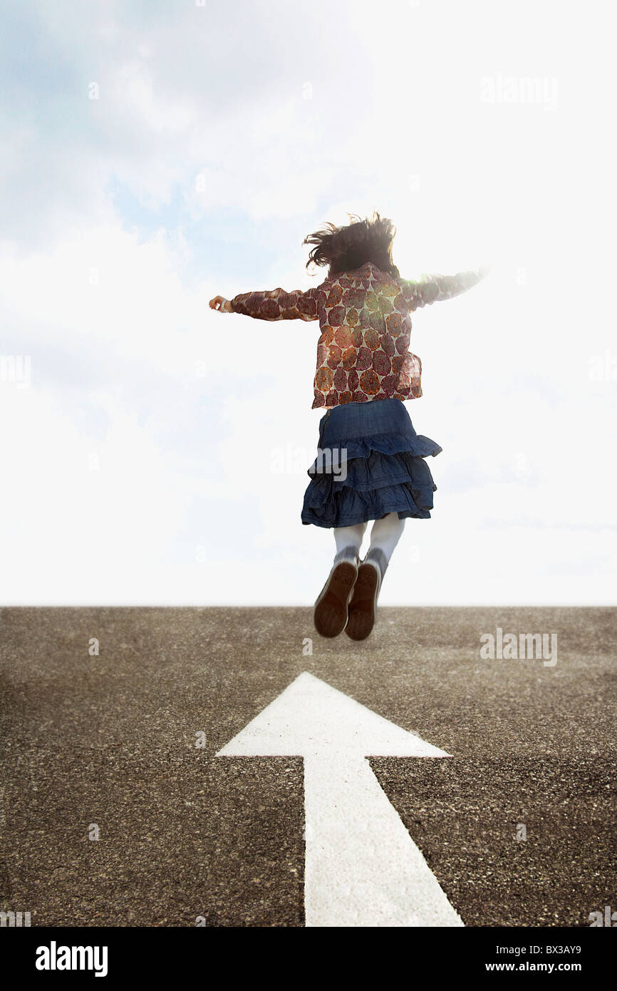 rear view of young girl jumping on road Stock Photo - Alamy