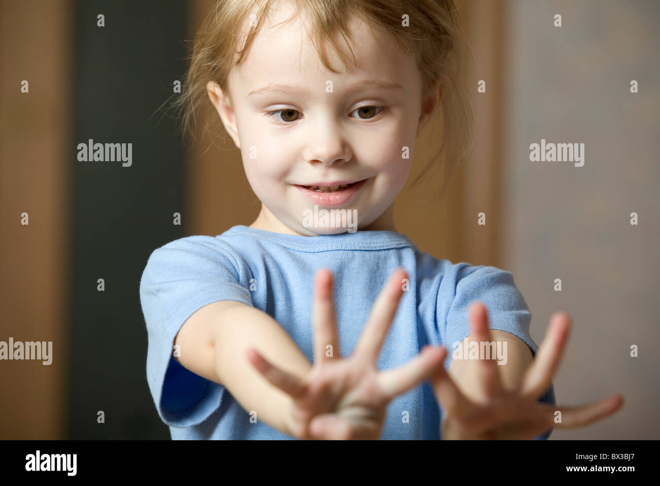 portrait of little girl looking at her hands Stock Photo - Alamy