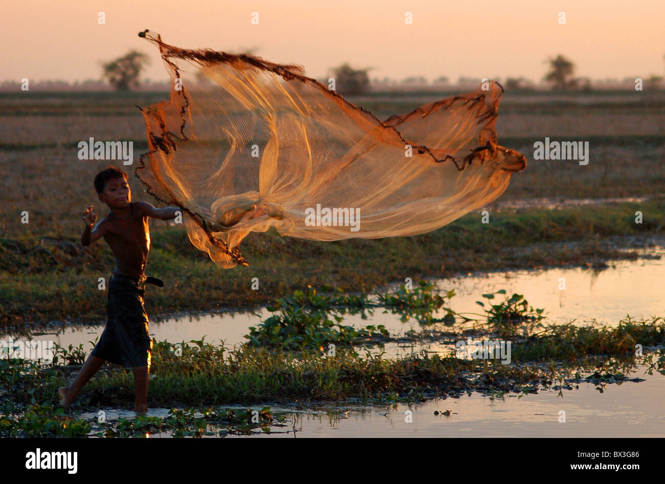 YOUNG BOY THROWING his FISHING NET Stock Photo - Alamy