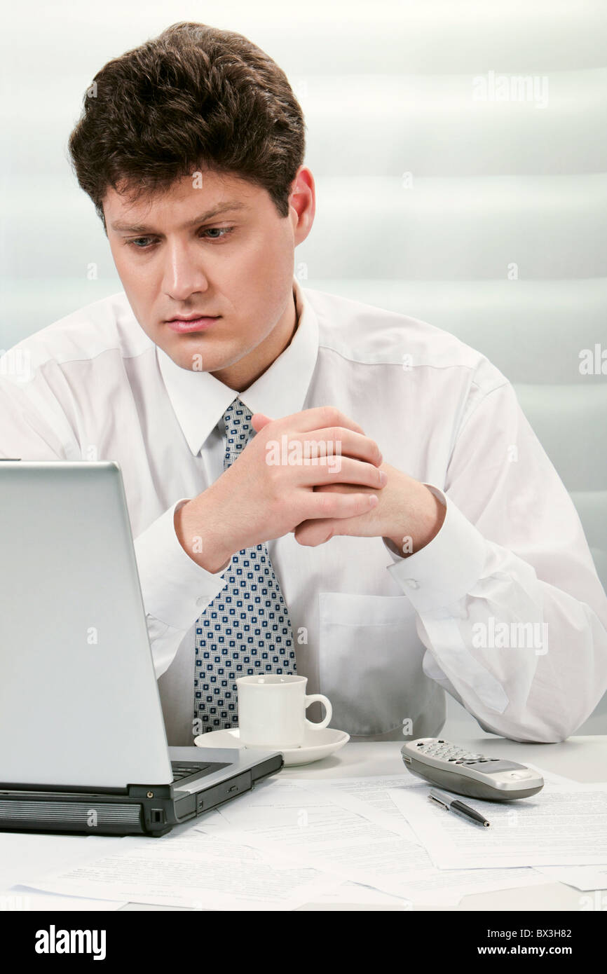 Portrait of smart businessman looking at laptop monitor seriously Stock ...