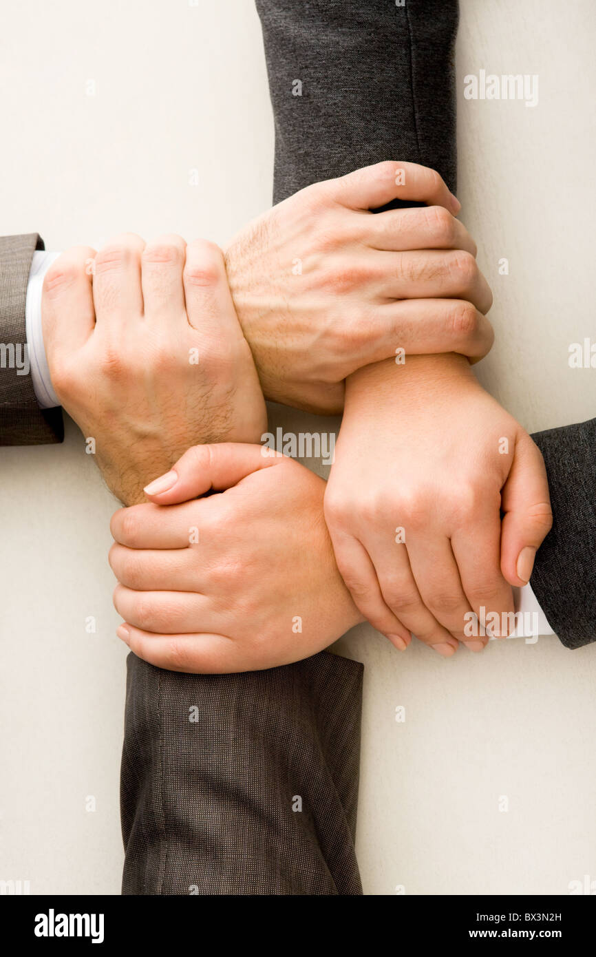 Image of crossed hands over workplace Stock Photo - Alamy