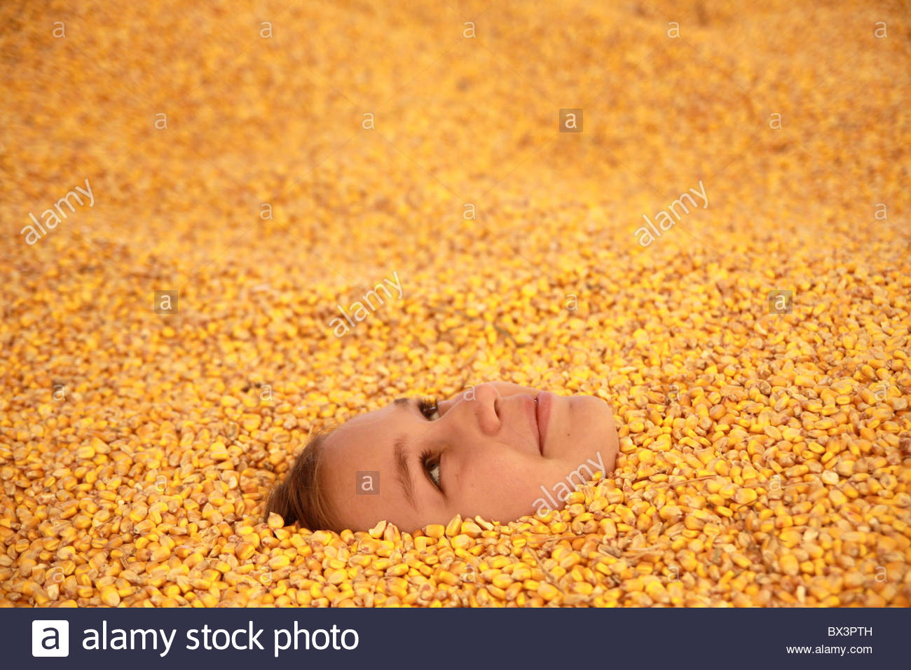 A young girl buried up to her face in a corn pit Stock Photo, Royalty ...