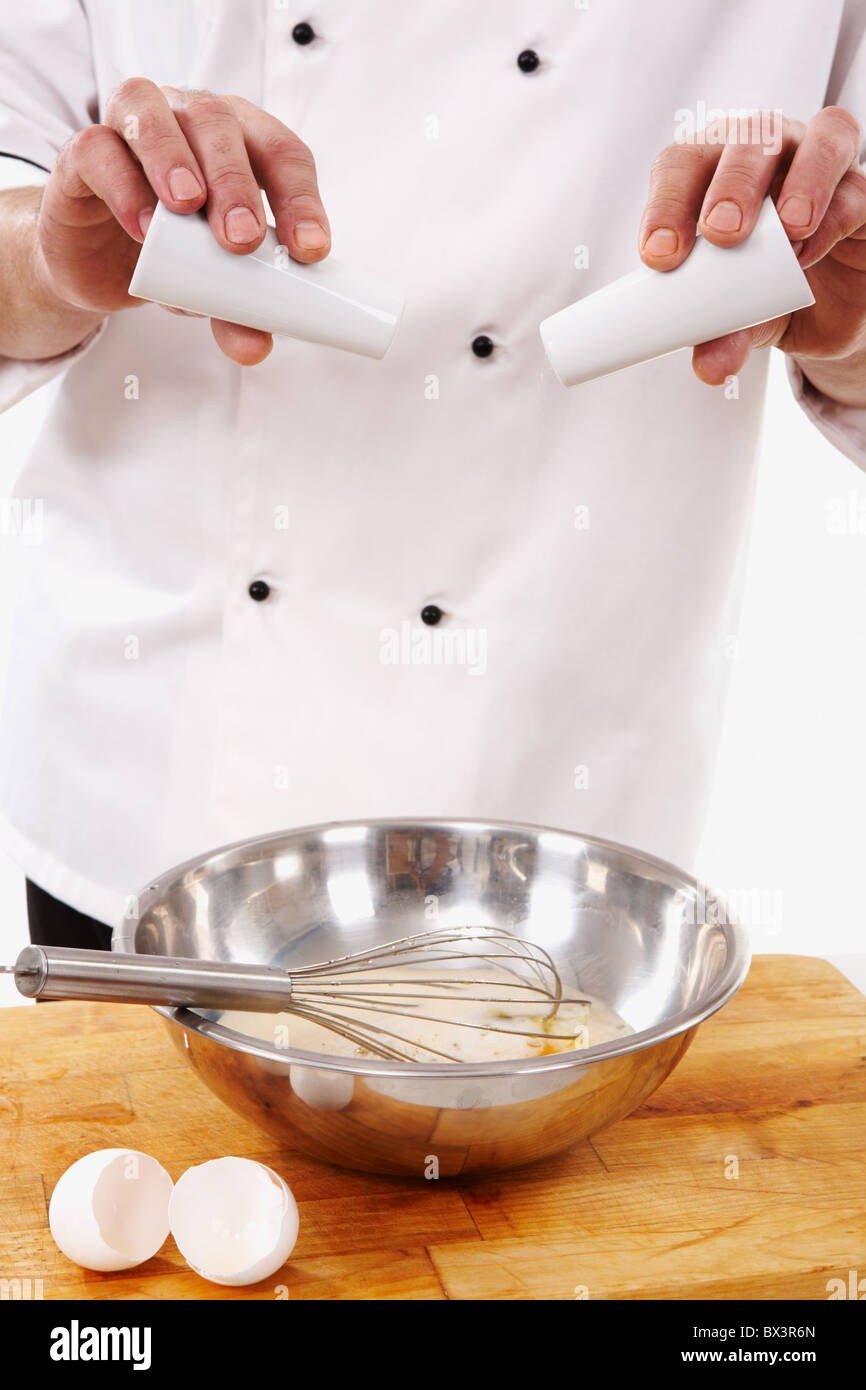 Image of cook hands with salt and pepper over omelette mixture Stock ...