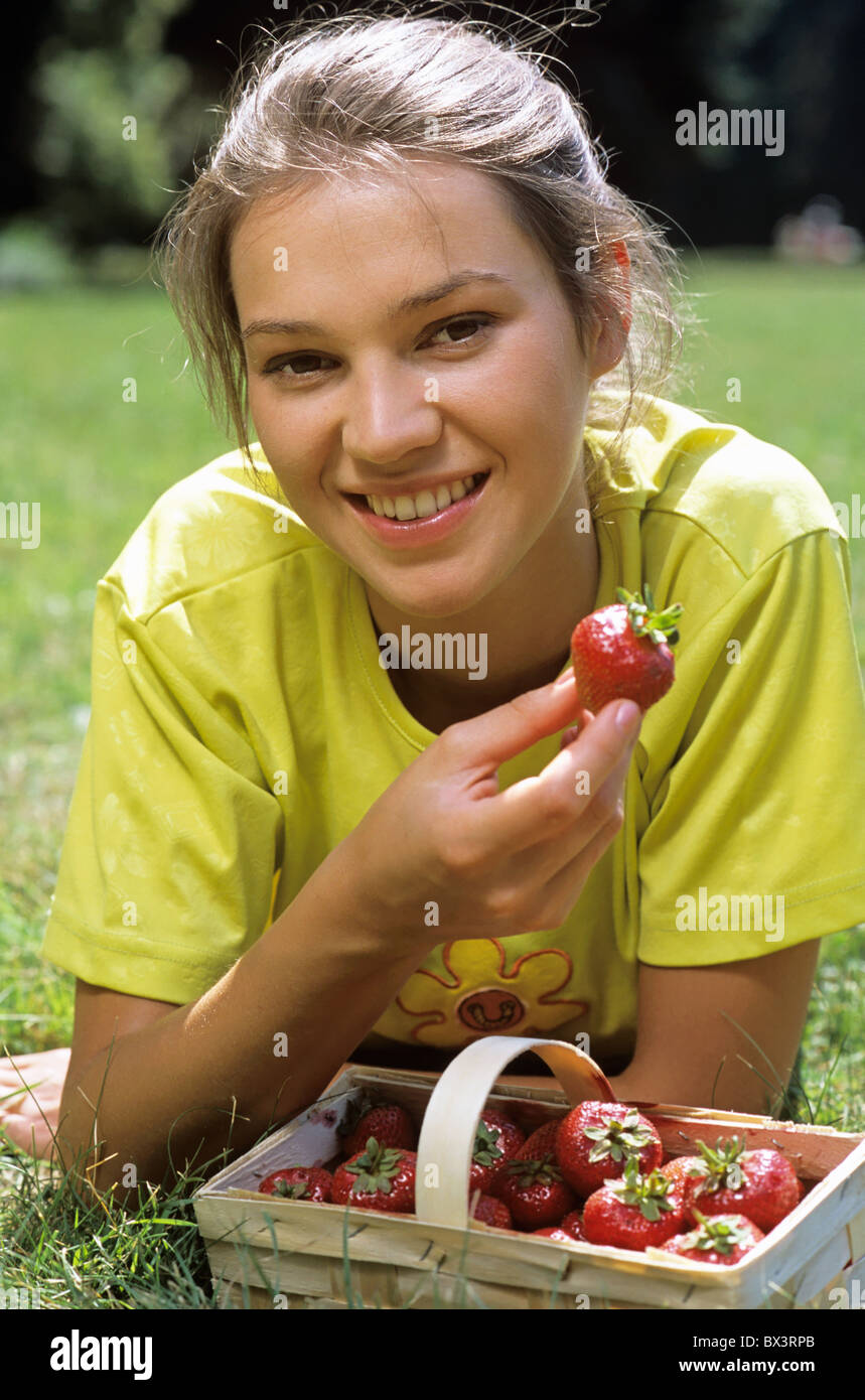 Girl eating strawberries on the meadow in the summer Stock Photo - Alamy