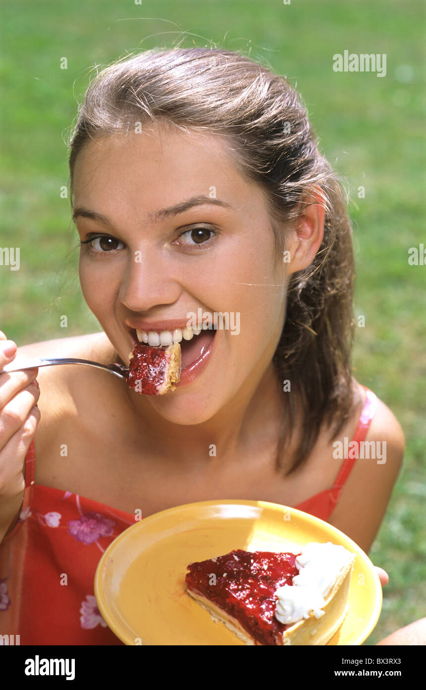 Girl eating cake on the meadow in the summer Stock Photo - Alamy