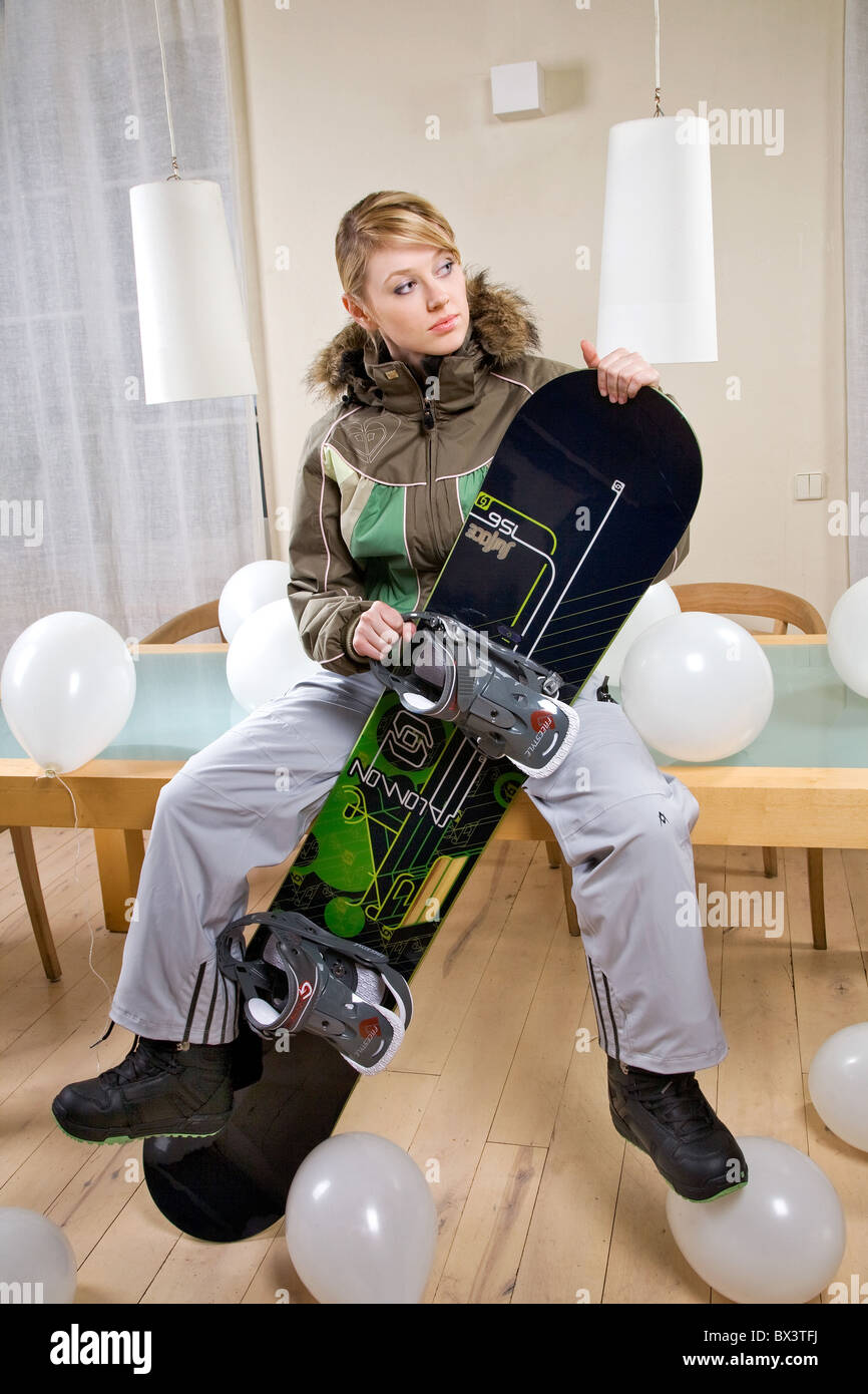 Young woman at home with snowboarding equipment Stock Photo - Alamy