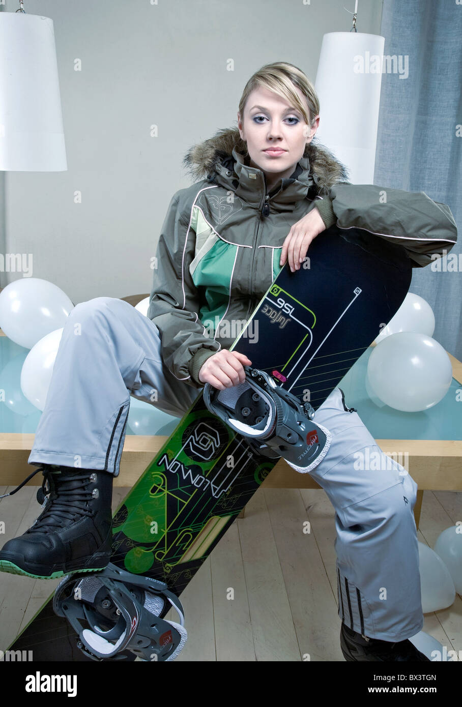 Young woman at home with snowboarding equipment Stock Photo - Alamy