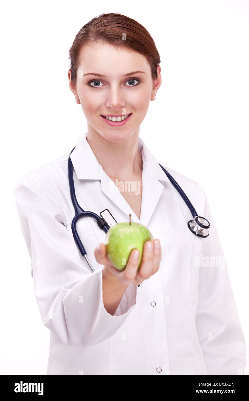 Smiling doctor with apple in her hand, likes she is giving it to you ...