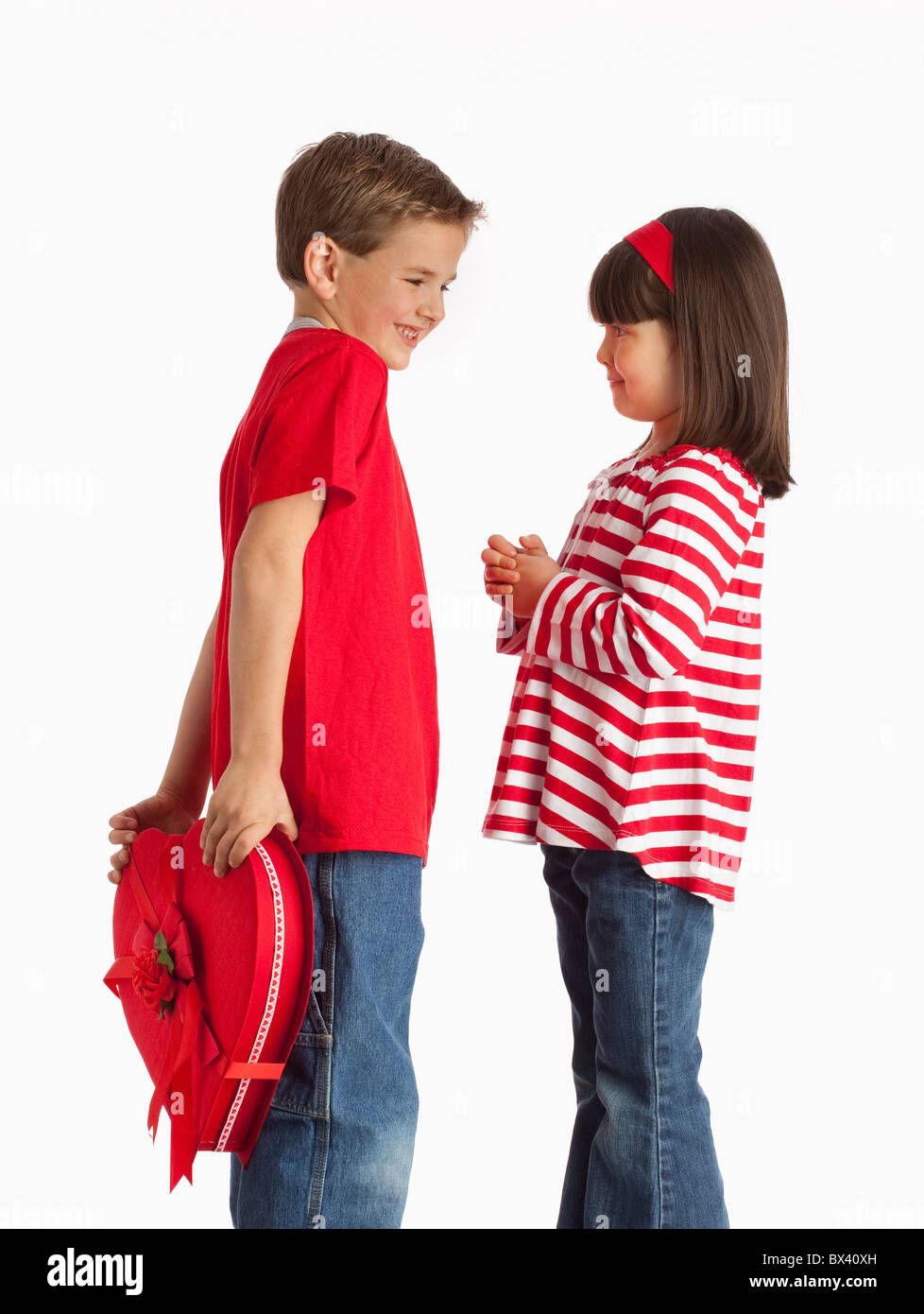 A Boy Hides A Heart Shaped Box Behind His Back For A Girl Standing In ...