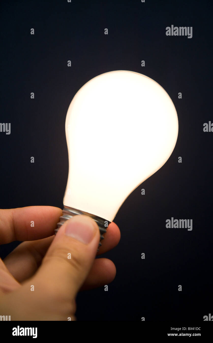 Hand holding a Bright Light Bulb, Concept of Inspiration, Ideas Stock ...