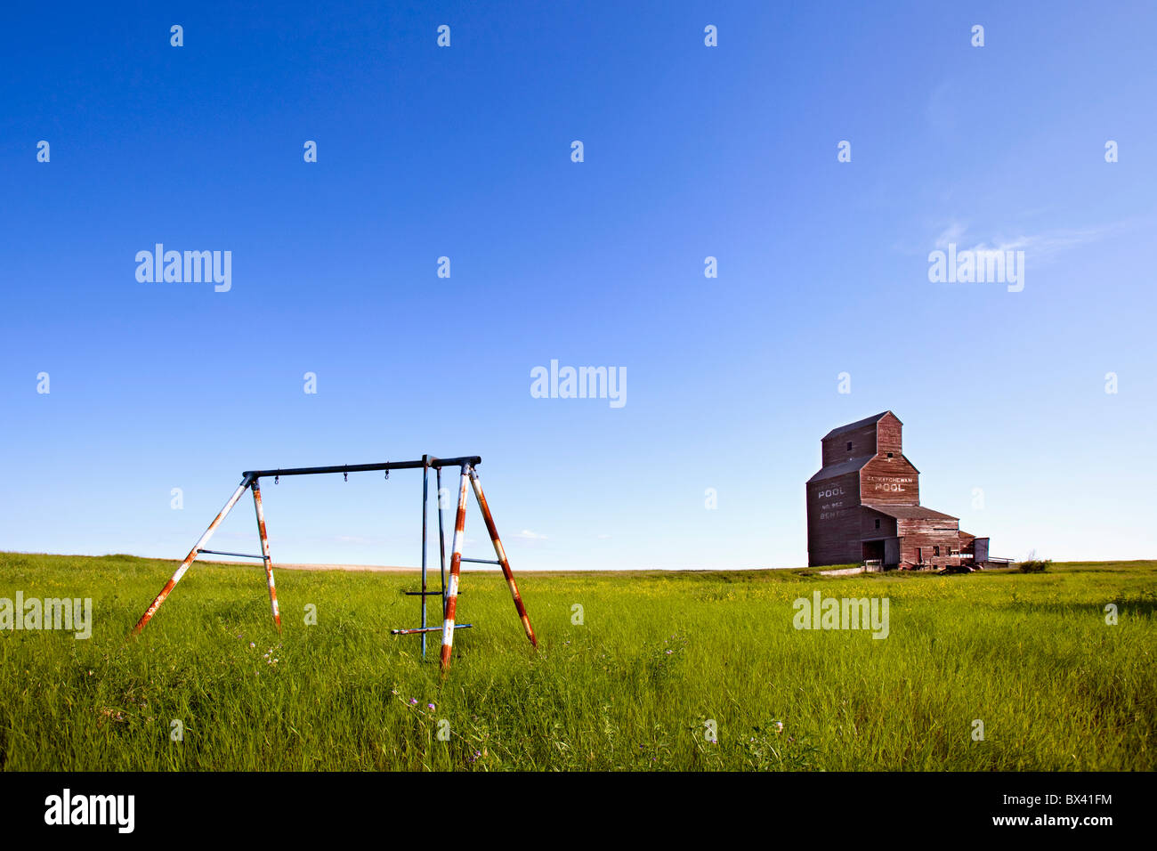 An Old Swing Set With A Grain Elevator Behind It In A Ghost Town; Bents ...