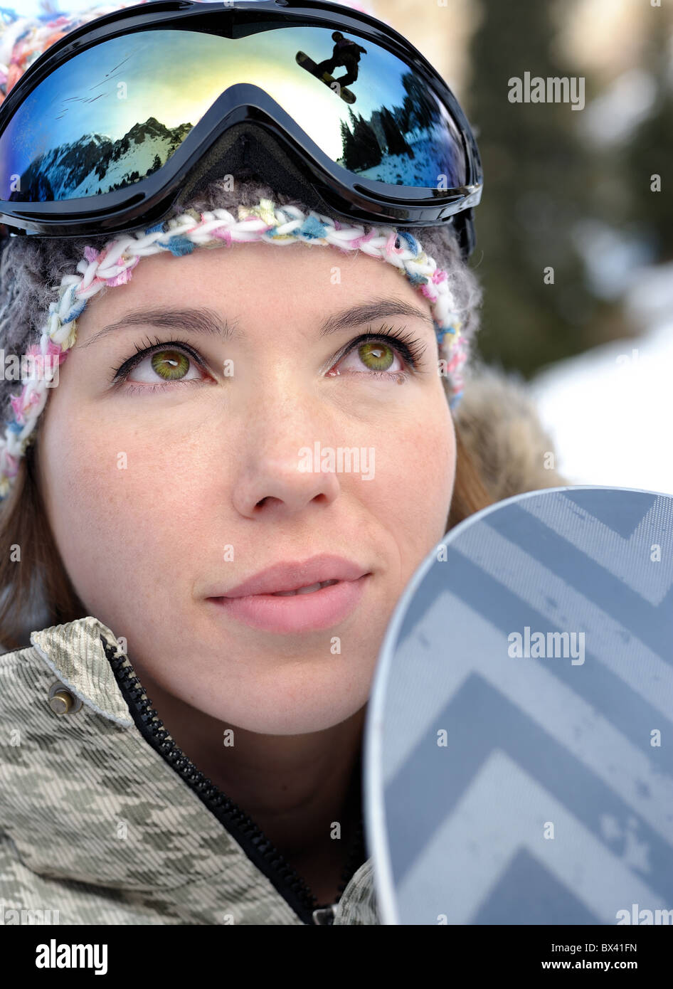 Pretty girl with snowboard looking up Stock Photo - Alamy