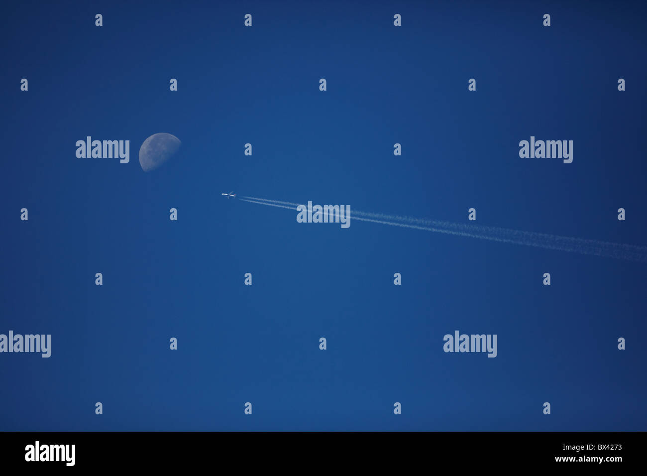Airplane flying across the moon Stock Photo - Alamy
