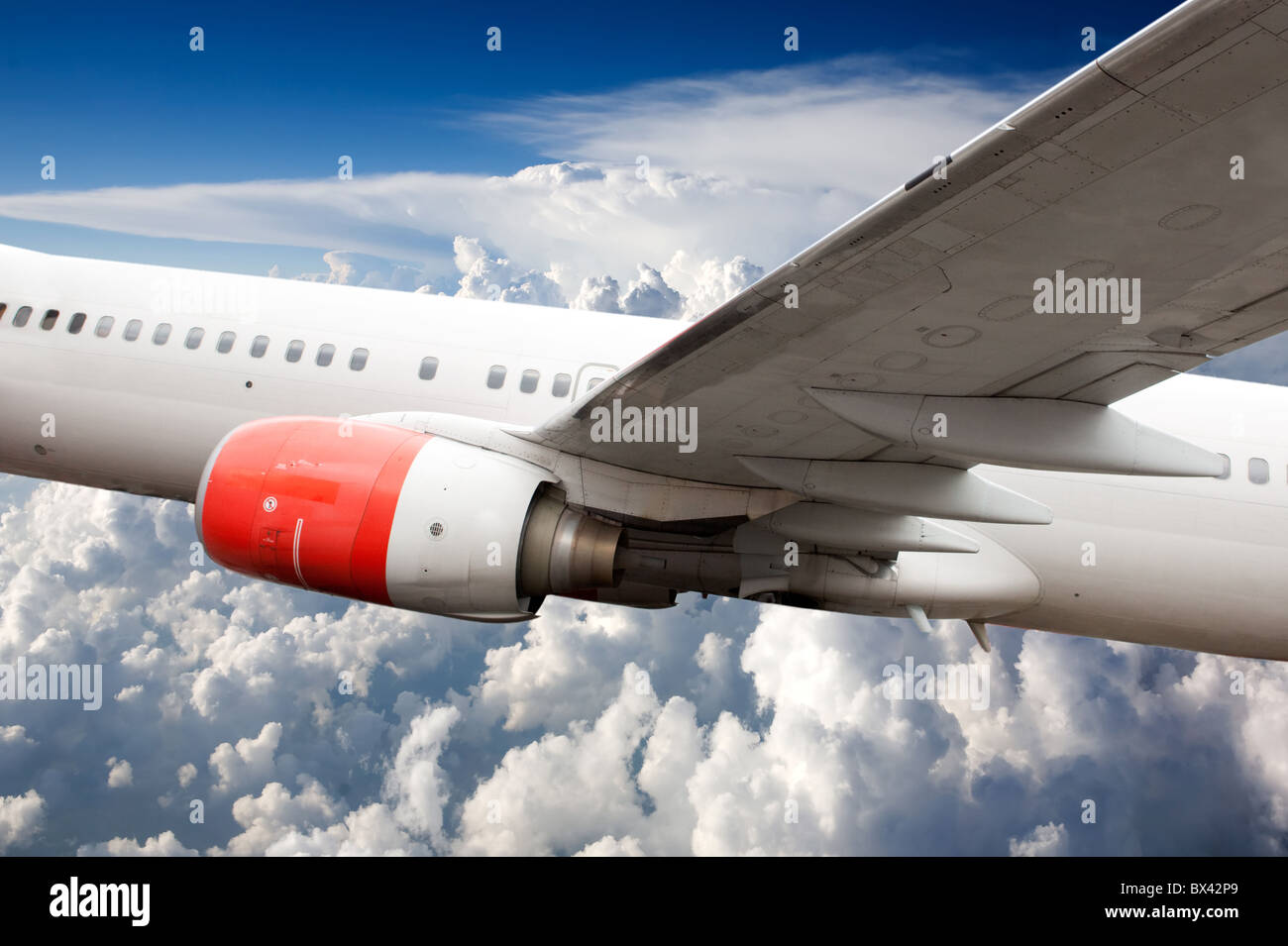 A large commercial passenger airplane in flight over clouds Stock Photo ...