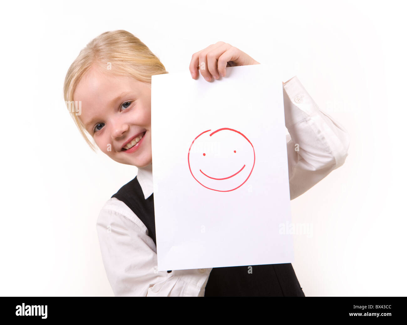 Portrait of pretty girl with drawing of happy face looking at camera ...