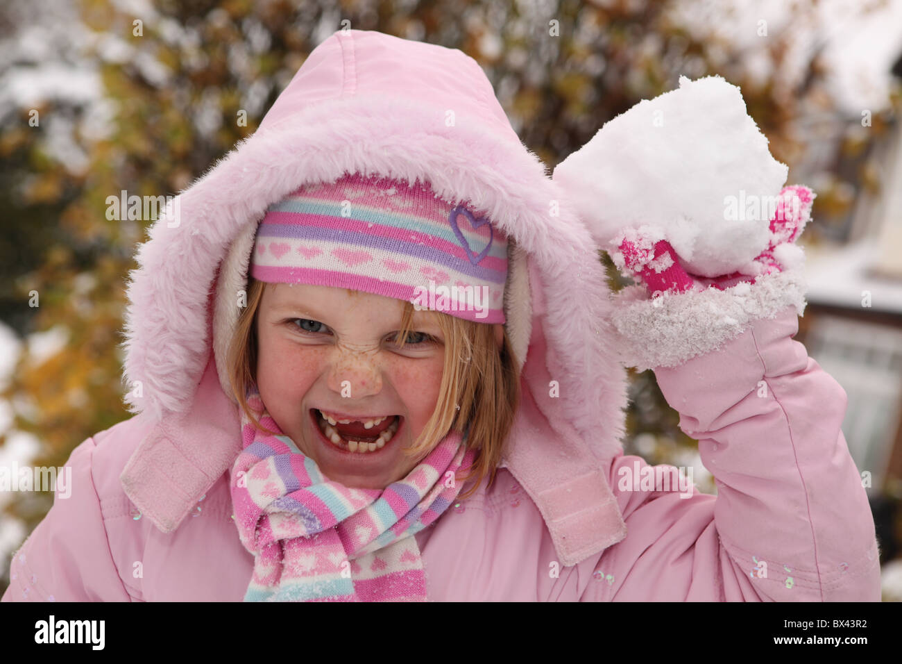 A young cheeky girl ready to throw a snowball Stock Photo - Alamy