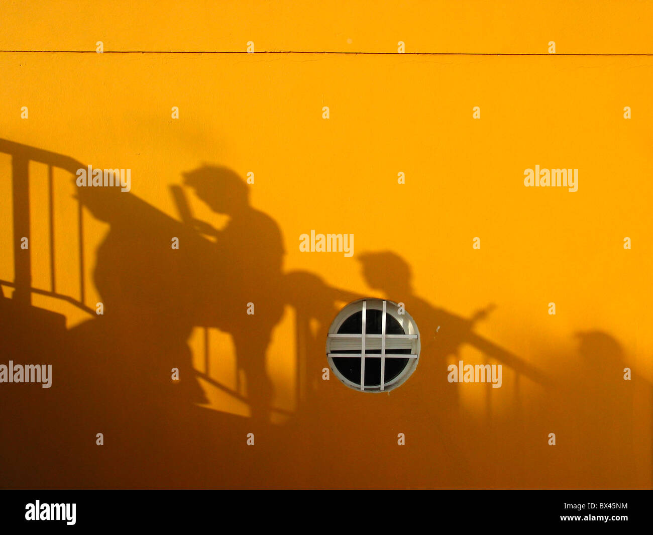 people pedestrian shadow throw shade silhouettes wall yellow window ...