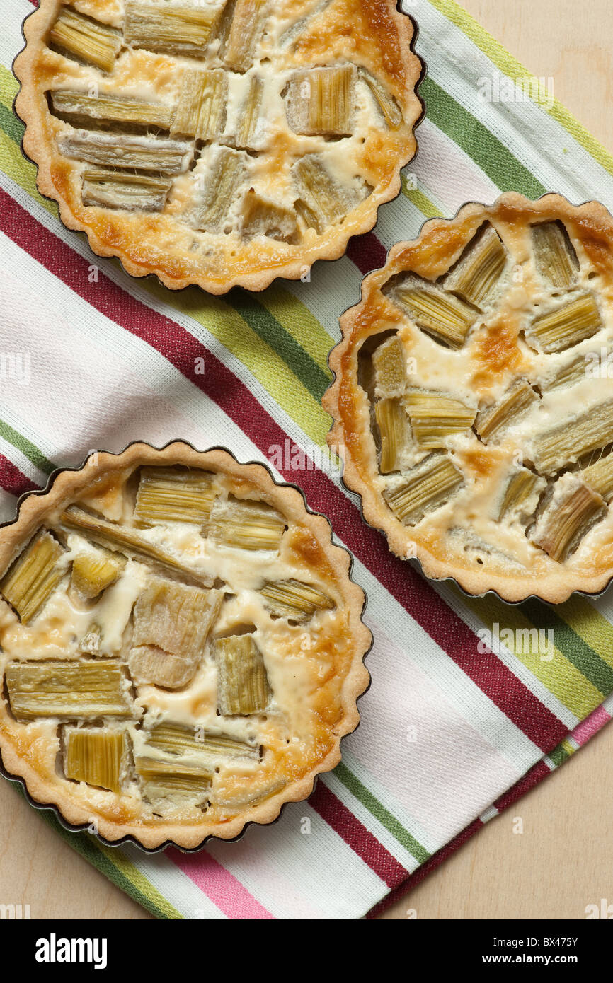 three rhubarb tartlets on a linen background Stock Photo - Alamy
