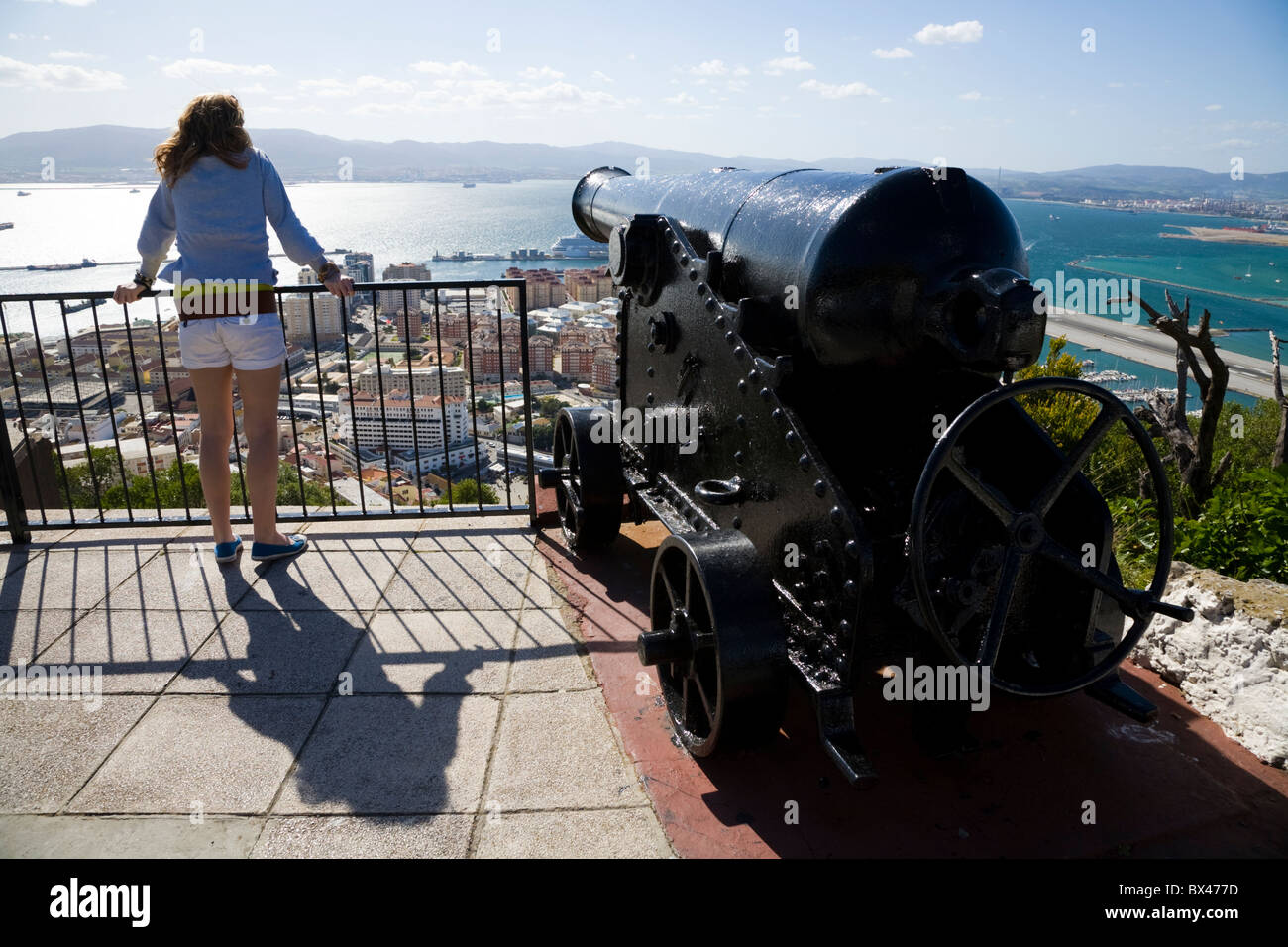 Young girl / tourist looks towards Spain over Gibraltar airport beside ...