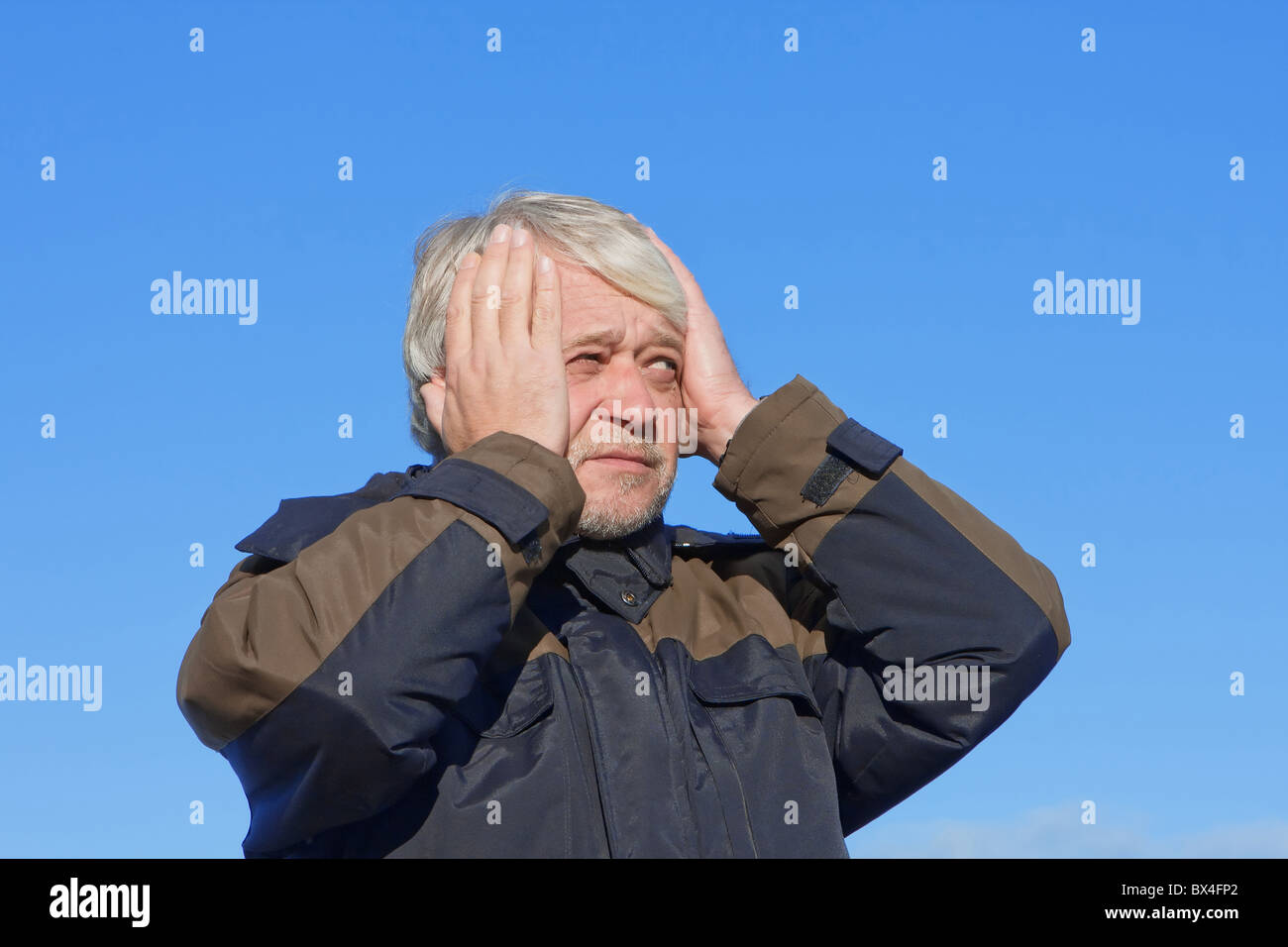 Portrait of mature concerned man with grey hair on blue sky of the ...