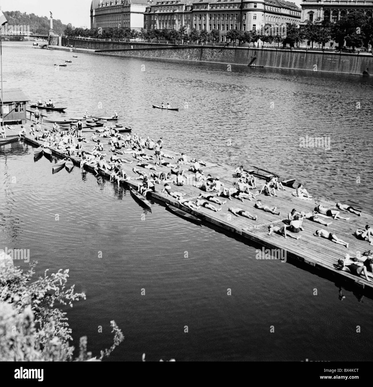 Prague 1938, sunbathers crowd the dock placed in the Vltava River which ...