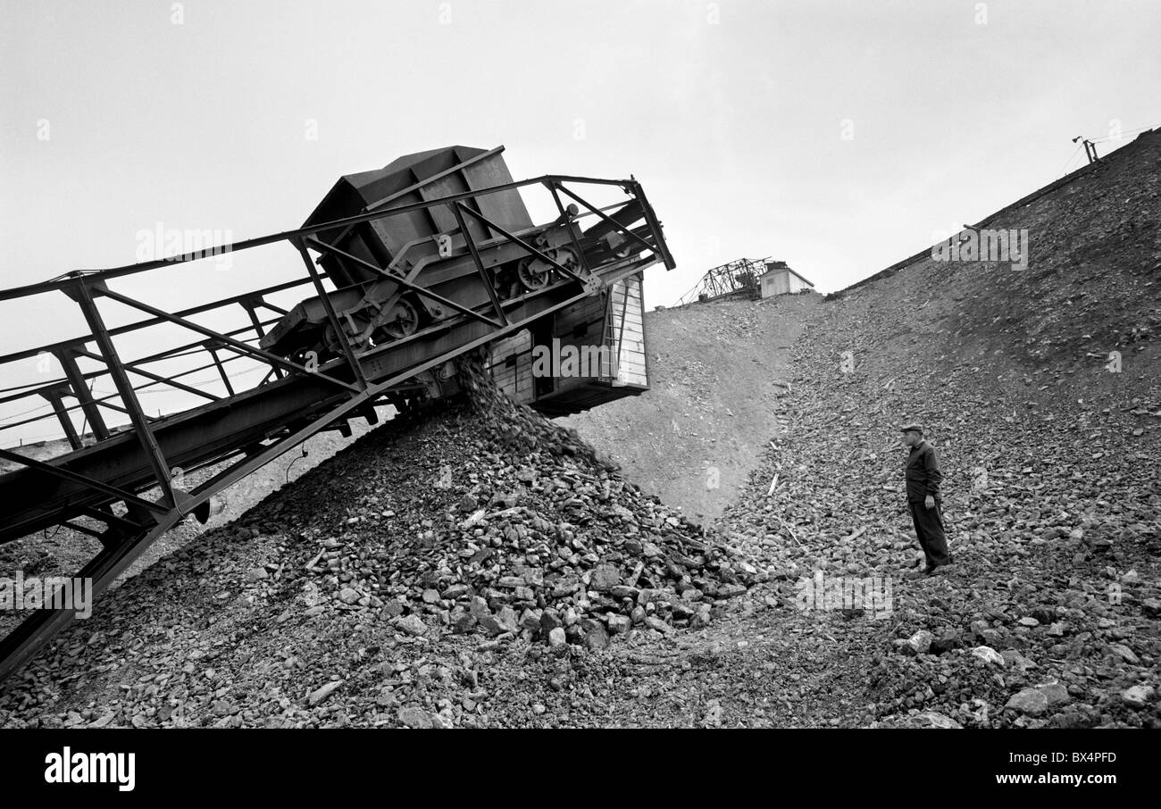 Man observes large coveyor belt dumpig piles of debris Kladno ...