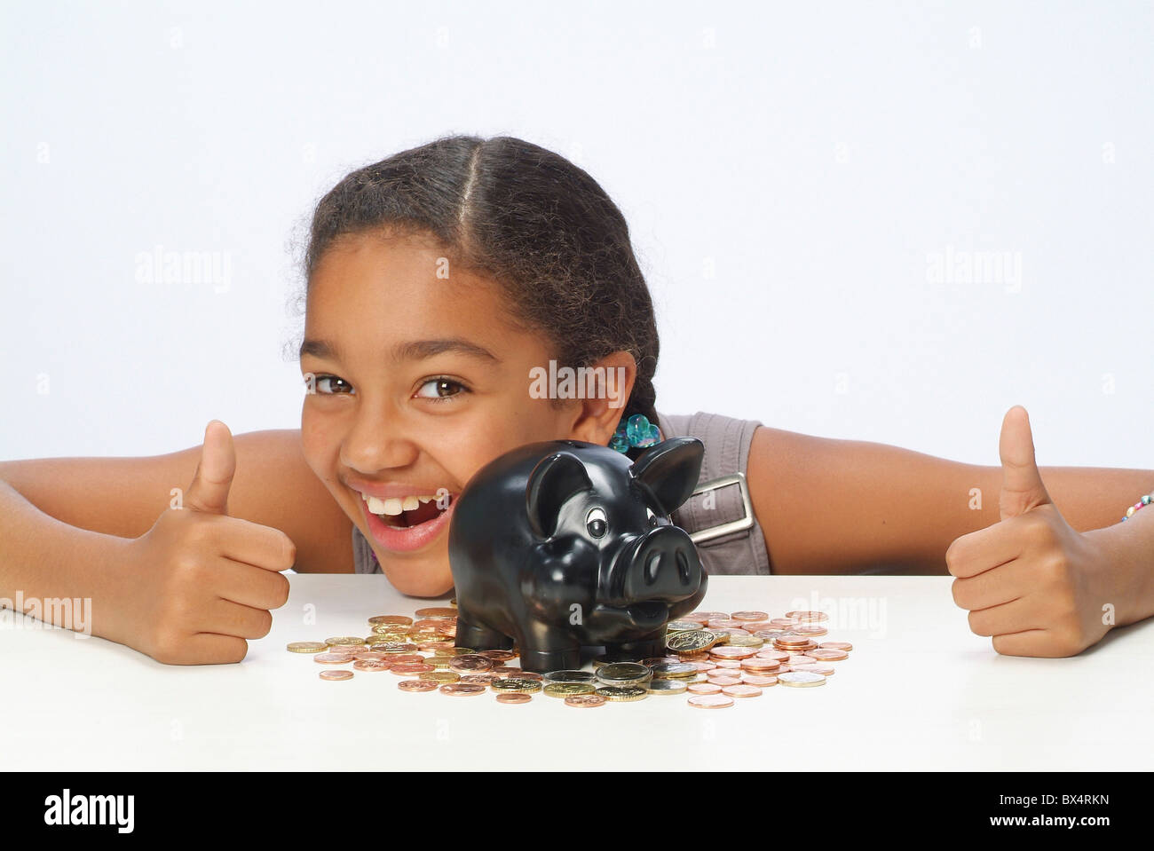 A girl with her savings and a piggy bank Stock Photo - Alamy