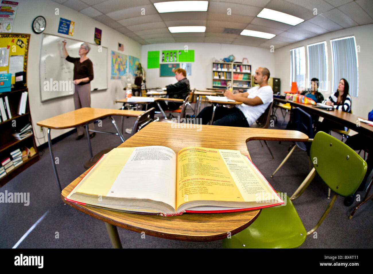 A teacher lectures about adjectives in a community adult basic literacy ...