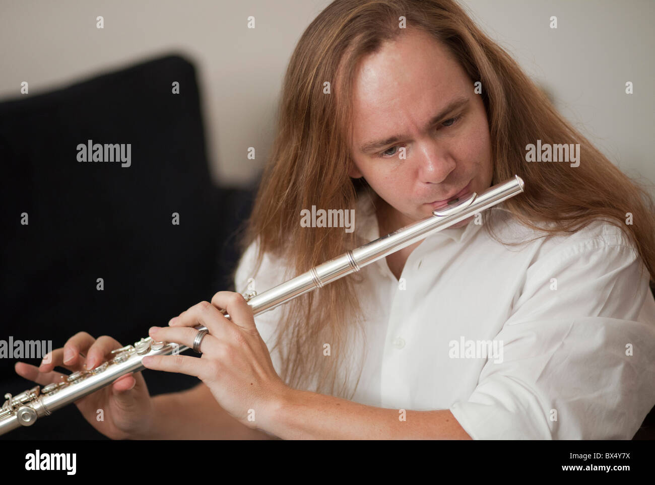 Long haired man playing flute hi-res stock photography and images - Alamy