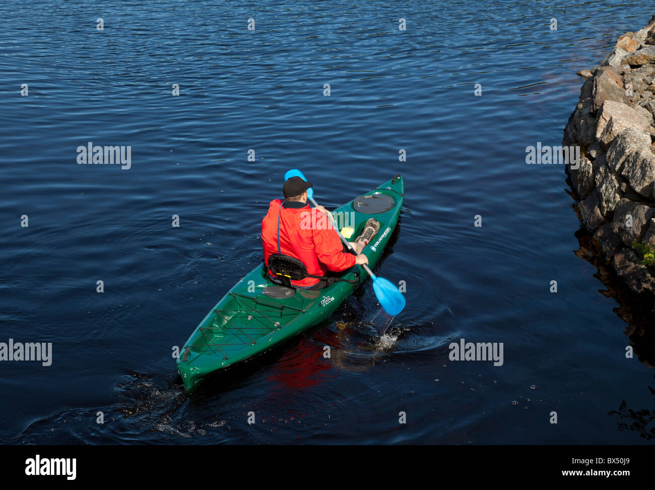 Obese man paddling with Wilderness Systems Ride 135 sit-on-top kayak ...
