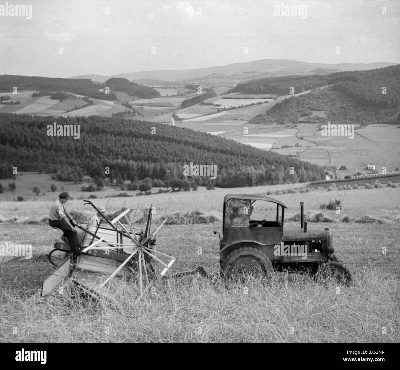 Czechoslovakia, whaet harvest. Man atop harvesting machine pulled by ...