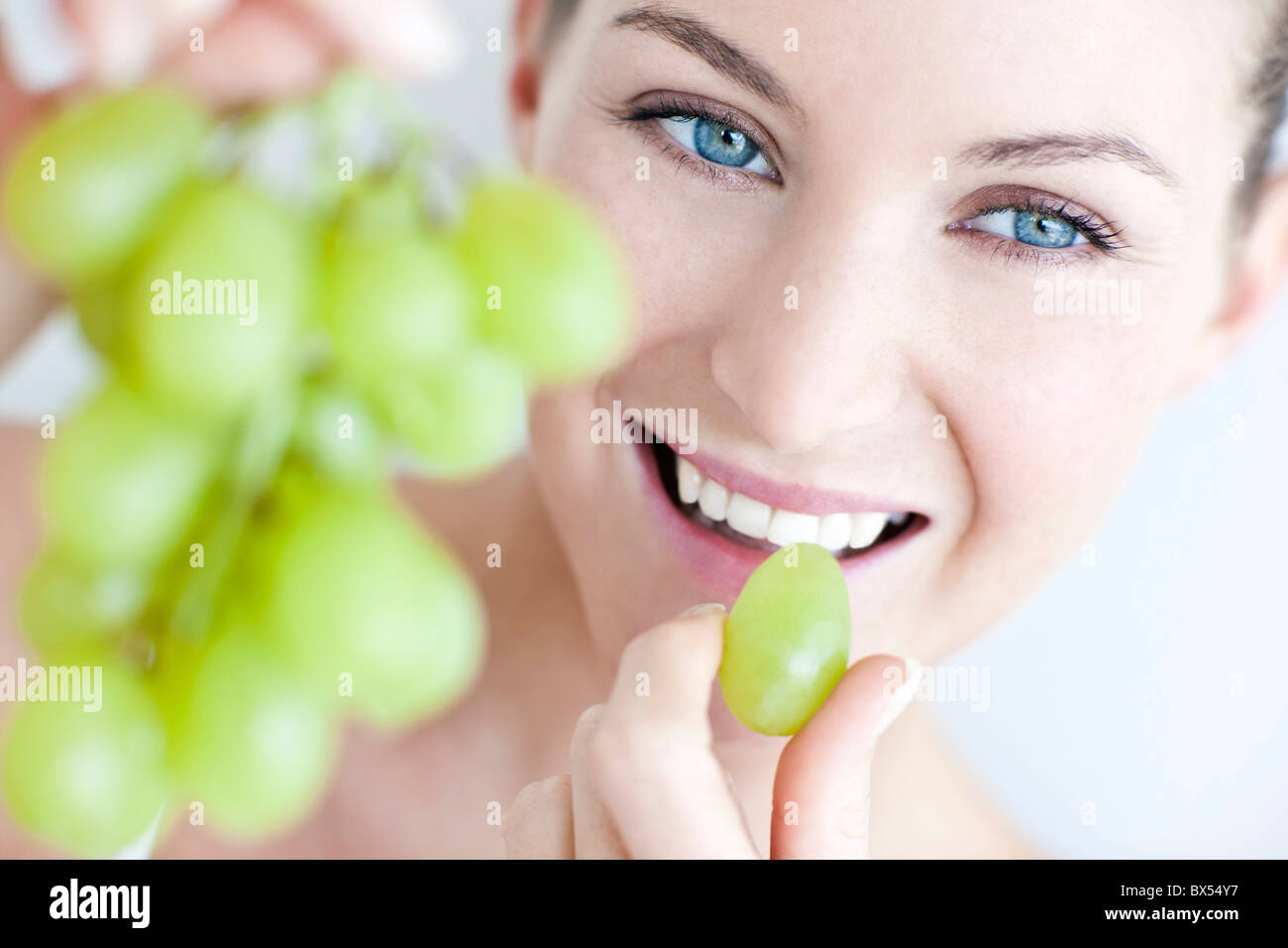 Woman eating grapes Stock Photo - Alamy
