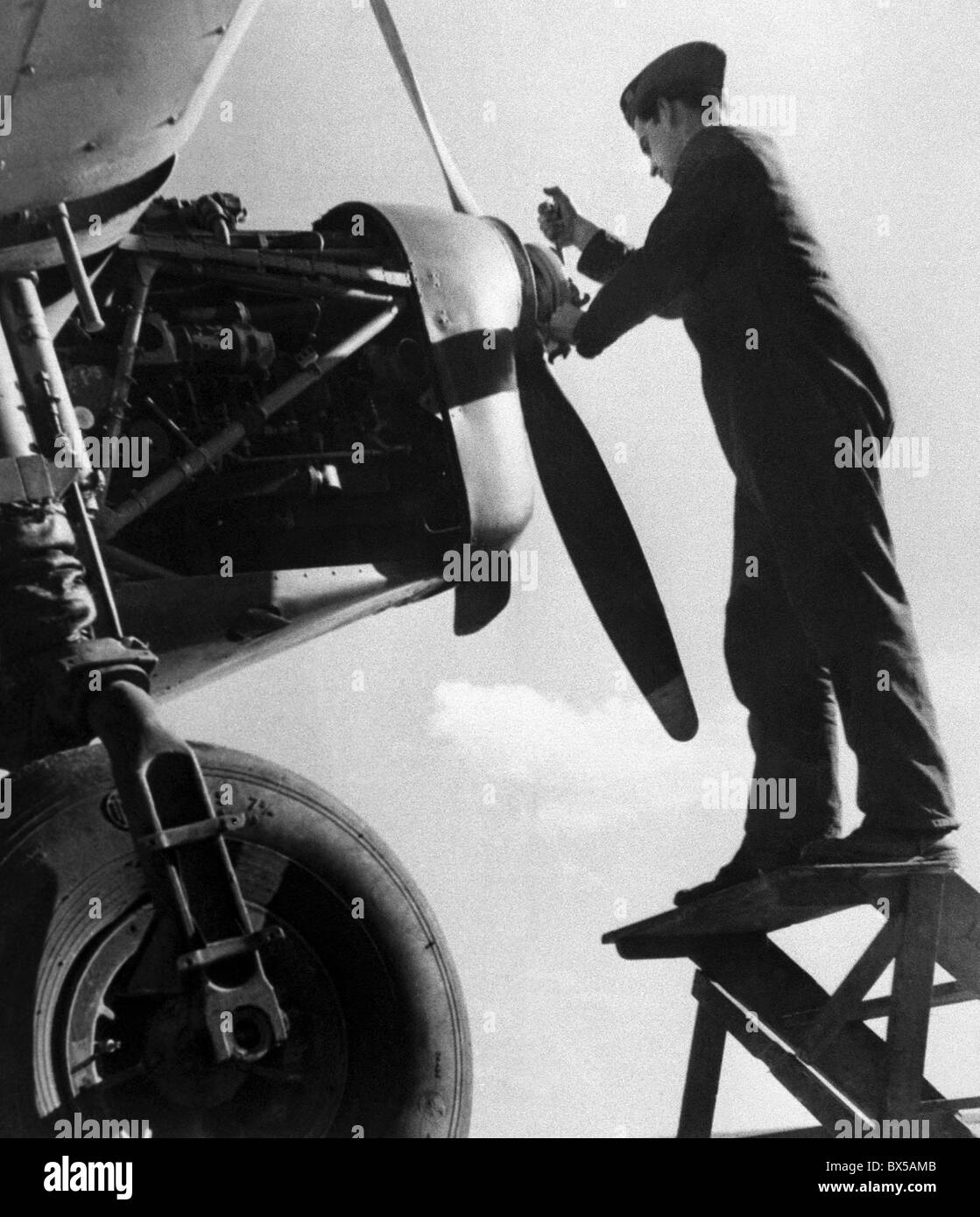 Czechoslovakia 1950. Aircraft mechanic starting the engine of propeller ...
