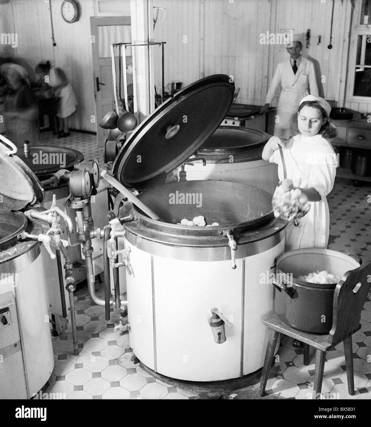 Cook loads giant cooking pot with meat ctk vintage photo hi-res stock ...