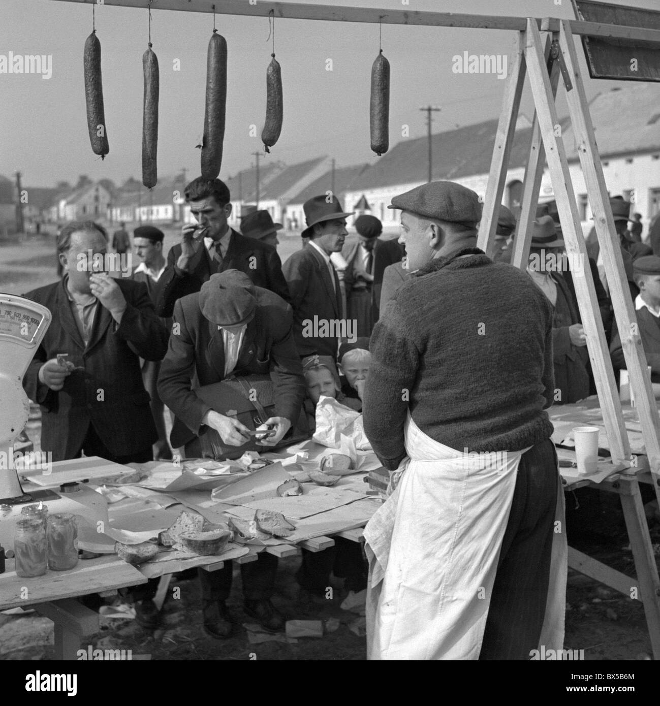 People at the stand with smoked meats at a village open-air food market ...
